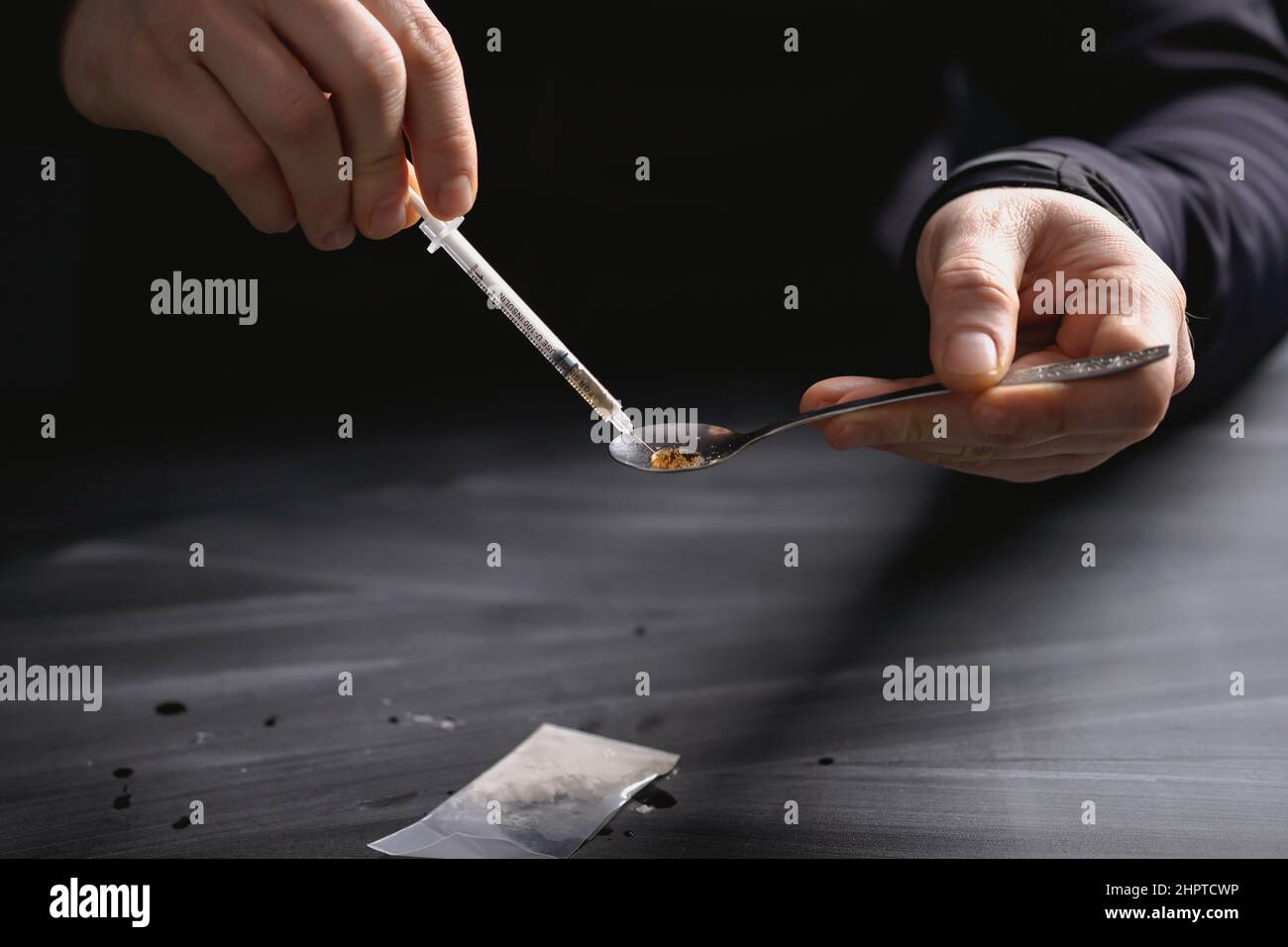 Addict/junkie man preparing drugs. The concept of crime and drug ...