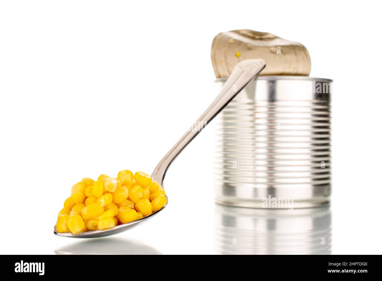 Bright yellow canned corn kernels in metal can and metal spoon, macro ...