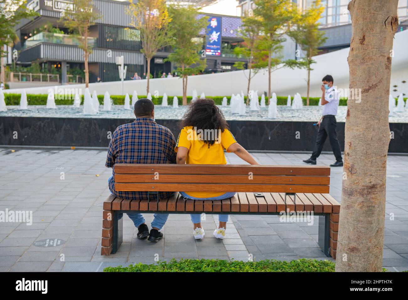 a couple of people sitting on a bench Stock Photo - Alamy