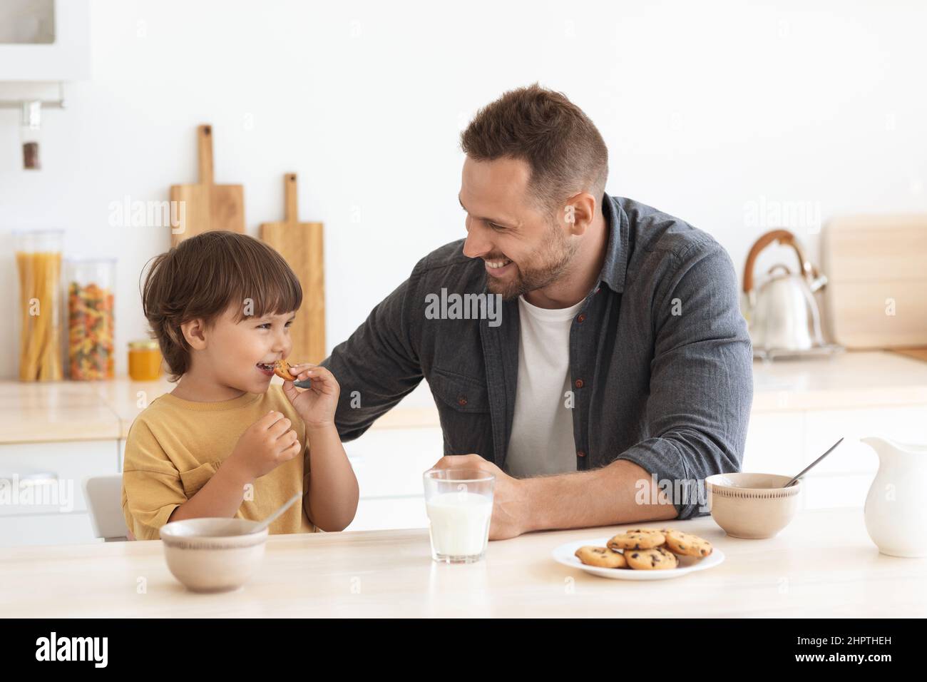 Healthy snack for kids. Cute little boy eating cookies with milk at ...