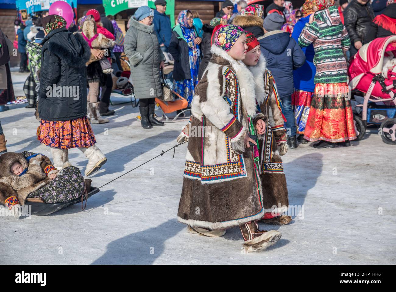 Nenet women pulling a plastic sled with a sleeping kid at the Reindeer ...