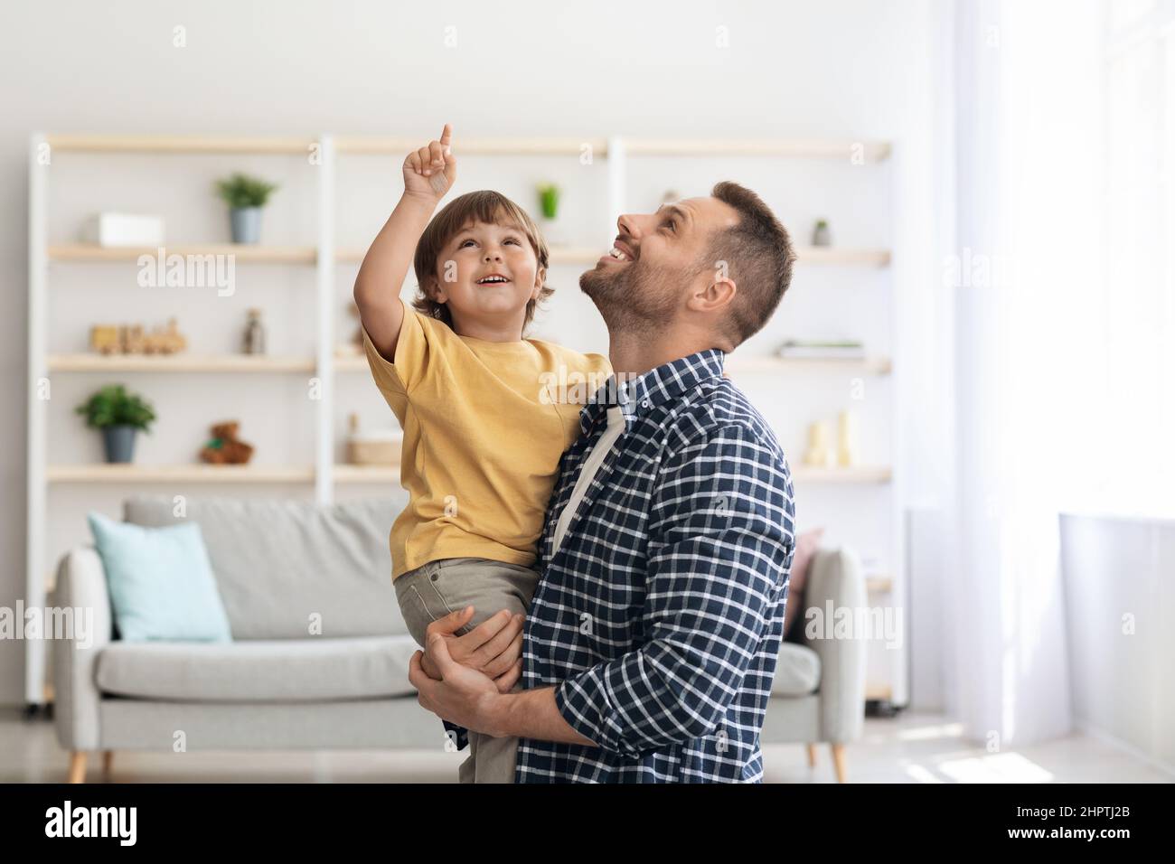 Daddy, look up. Excited little boy looking upwards with his father ...