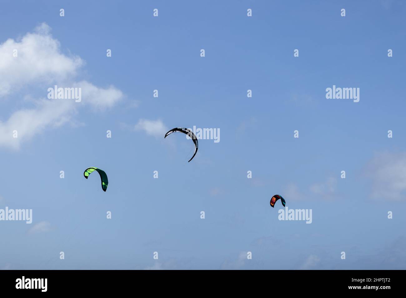 Three parachutes in the blue sky. Kiteboarding Stock Photo - Alamy