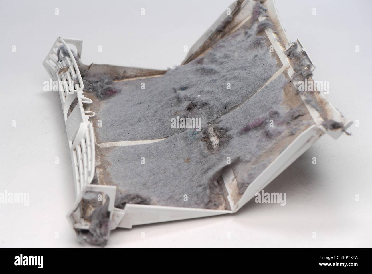 A tumble drier fluff filter catcher full of clothing fluff on a white ...