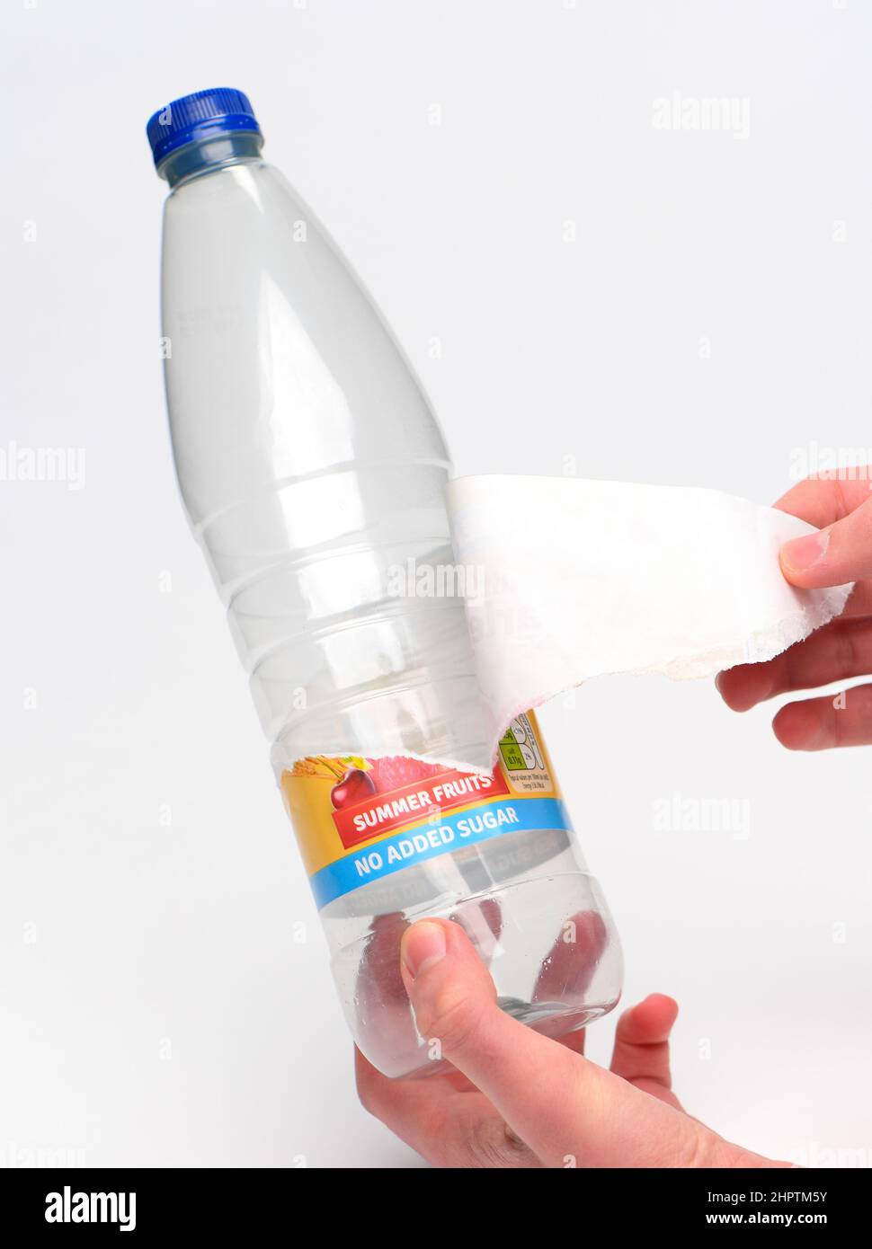 Removal of a paper label from a single use squash drinks plastic bottle ...