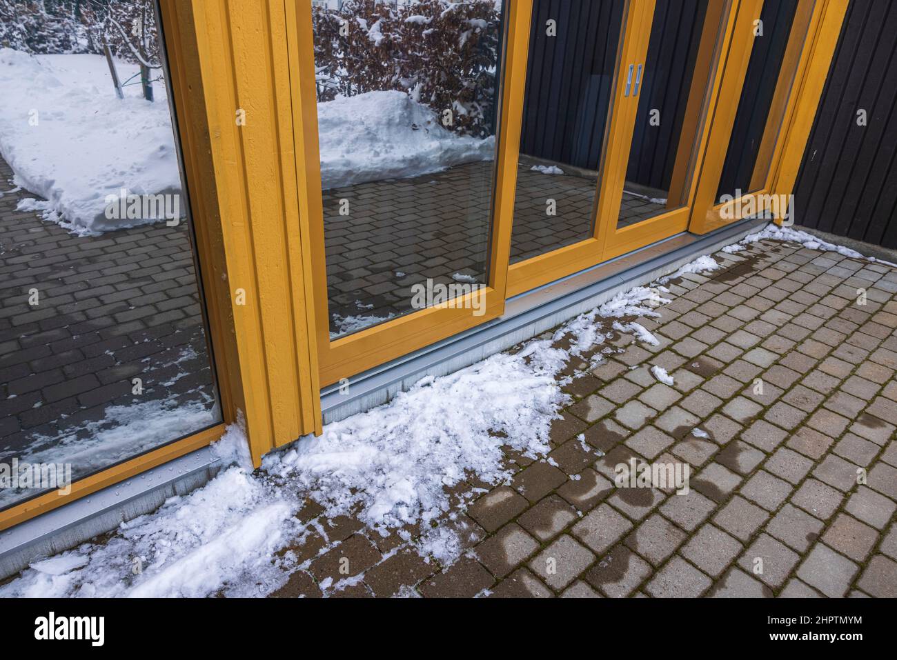 Exterior view of glass wall of modern house and icy paving slabs ...