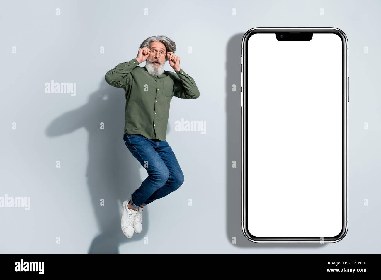 Photo of impressed cellphone poster discount man pensioner jumping high ...