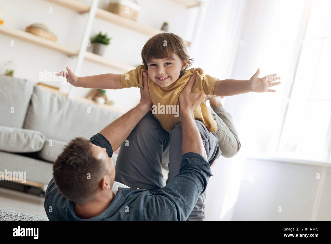 Fun with daddy. Portrait of adorable little boy playing with father at ...