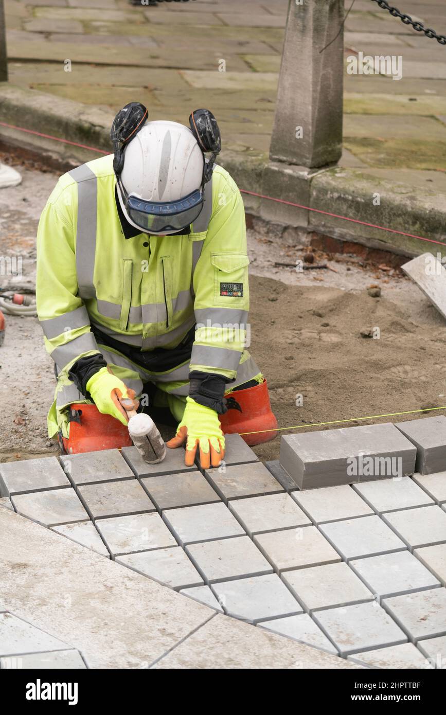 Construction worker laying new stone on the pavement Stock Photo - Alamy