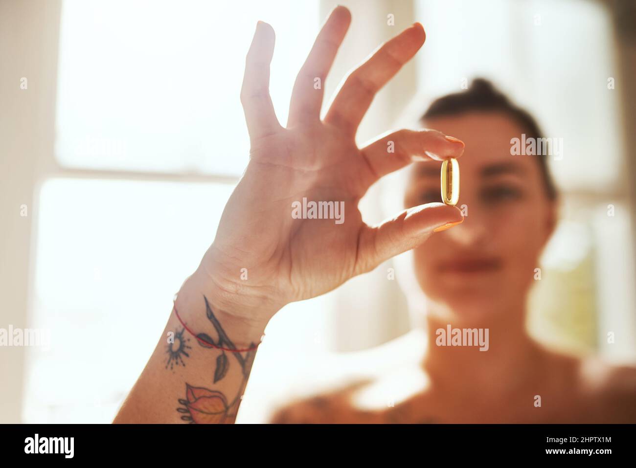Medicinal help for your health. Shot of a woman taking a pill during ...