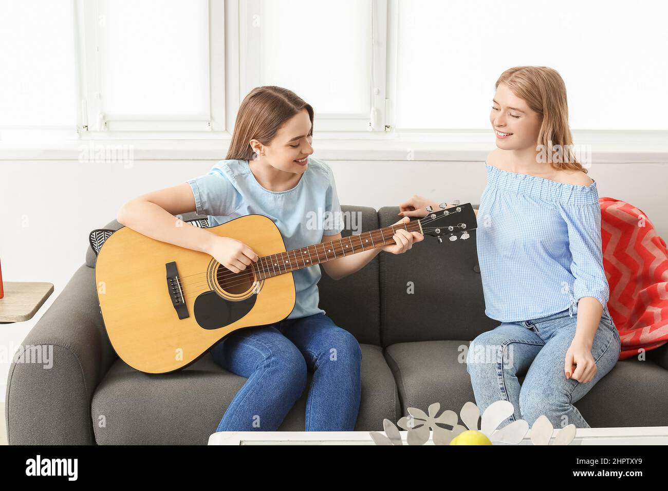 Happy young sisters playing guitar at home Stock Photo - Alamy