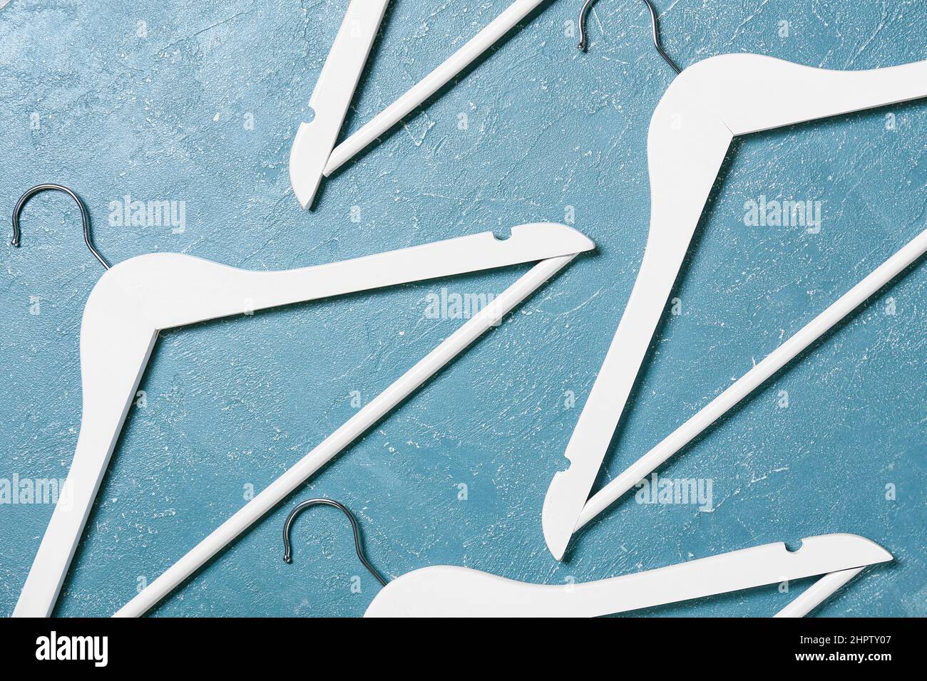 White clothes hangers on color background Stock Photo - Alamy