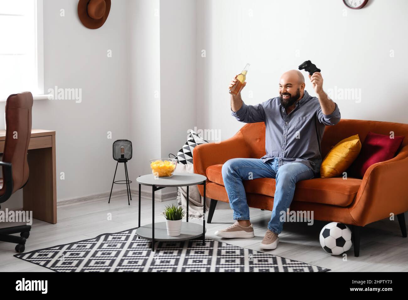 Funny lazy man drinking beer and playing video game at home Stock Photo ...