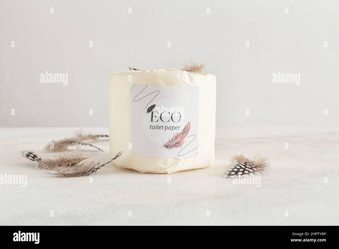 Toilet paper roll and feathers on light background Stock Photo - Alamy