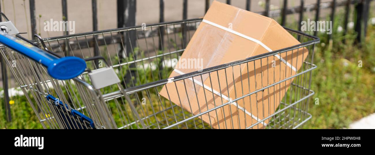 Shopping cart with carton box, a box in trolley Stock Photo - Alamy