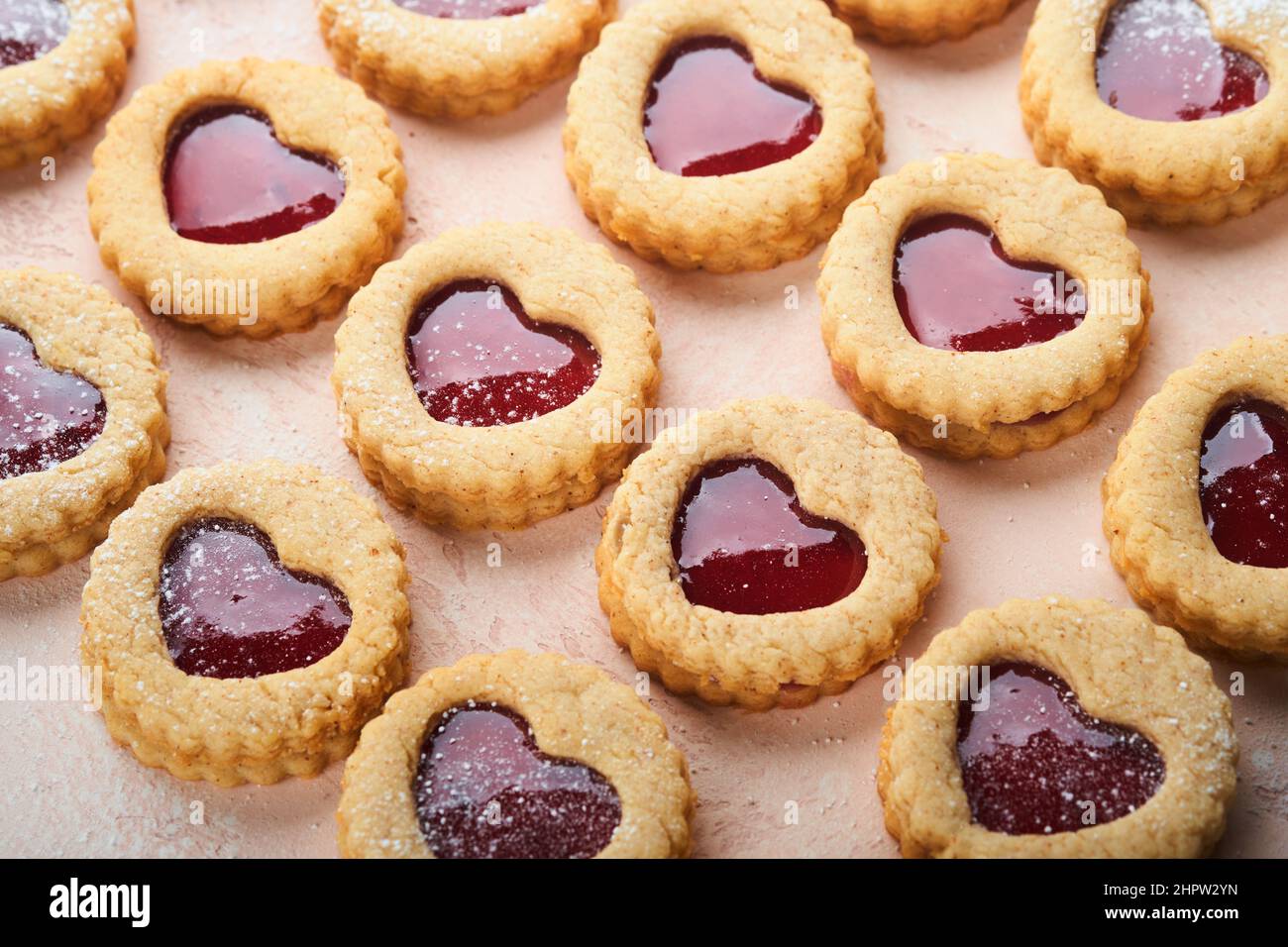 Traditional Linzer cookie with strawberry jam and powder sugar on pink ...