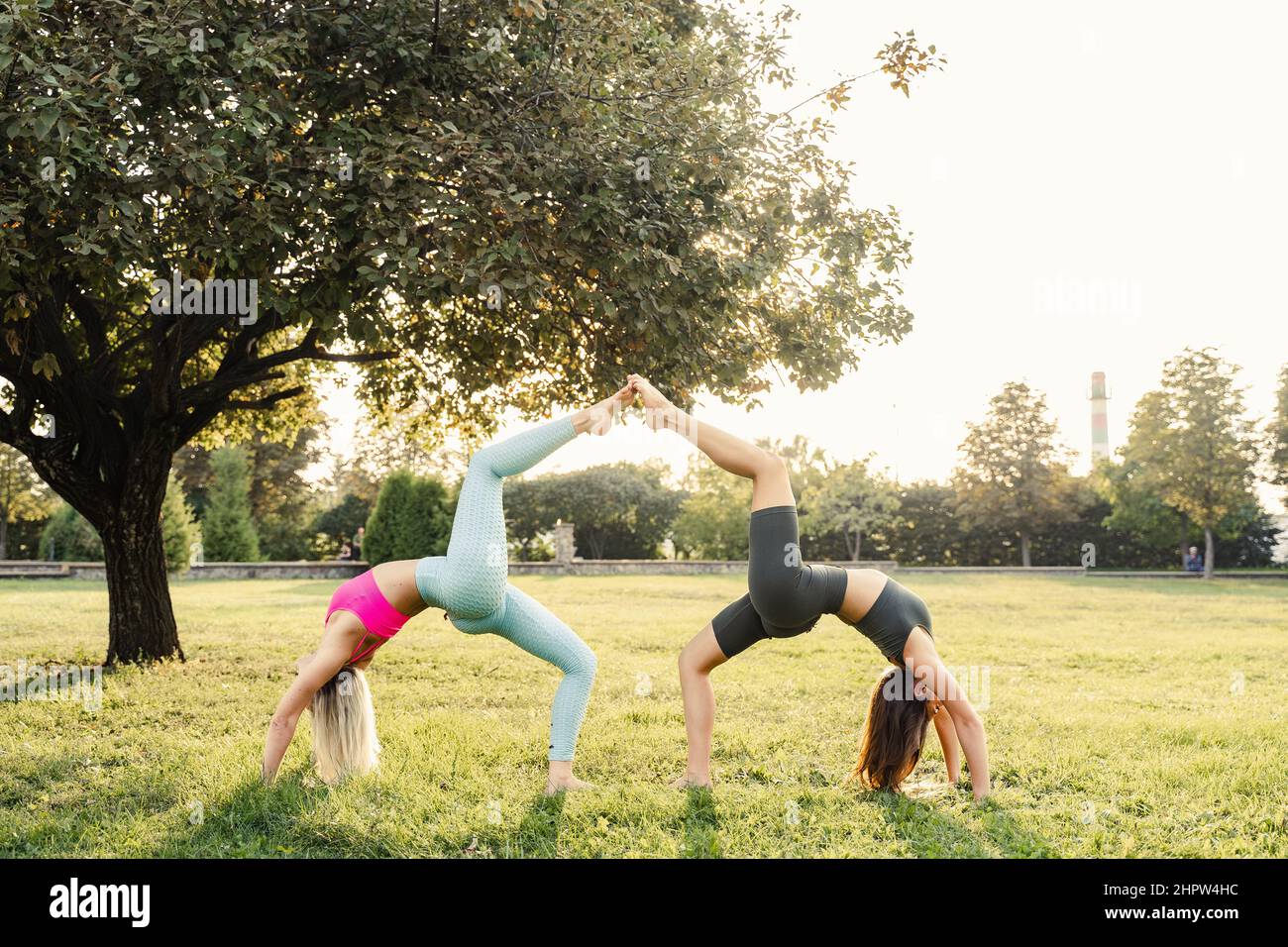 Yoga and gymnastics sport training of 2 girl outside in the park at ...