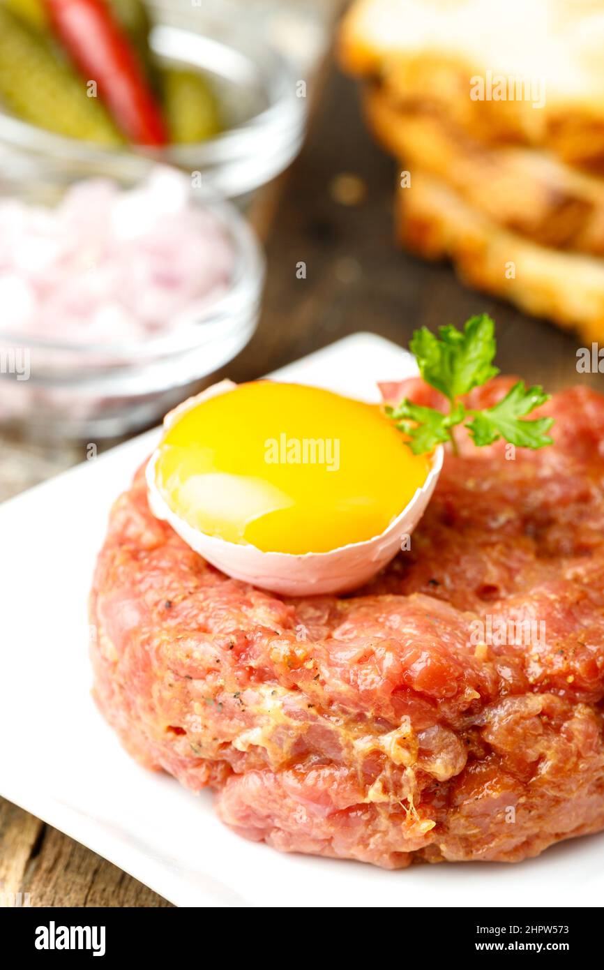 steak tartare with open egg on wood Stock Photo - Alamy
