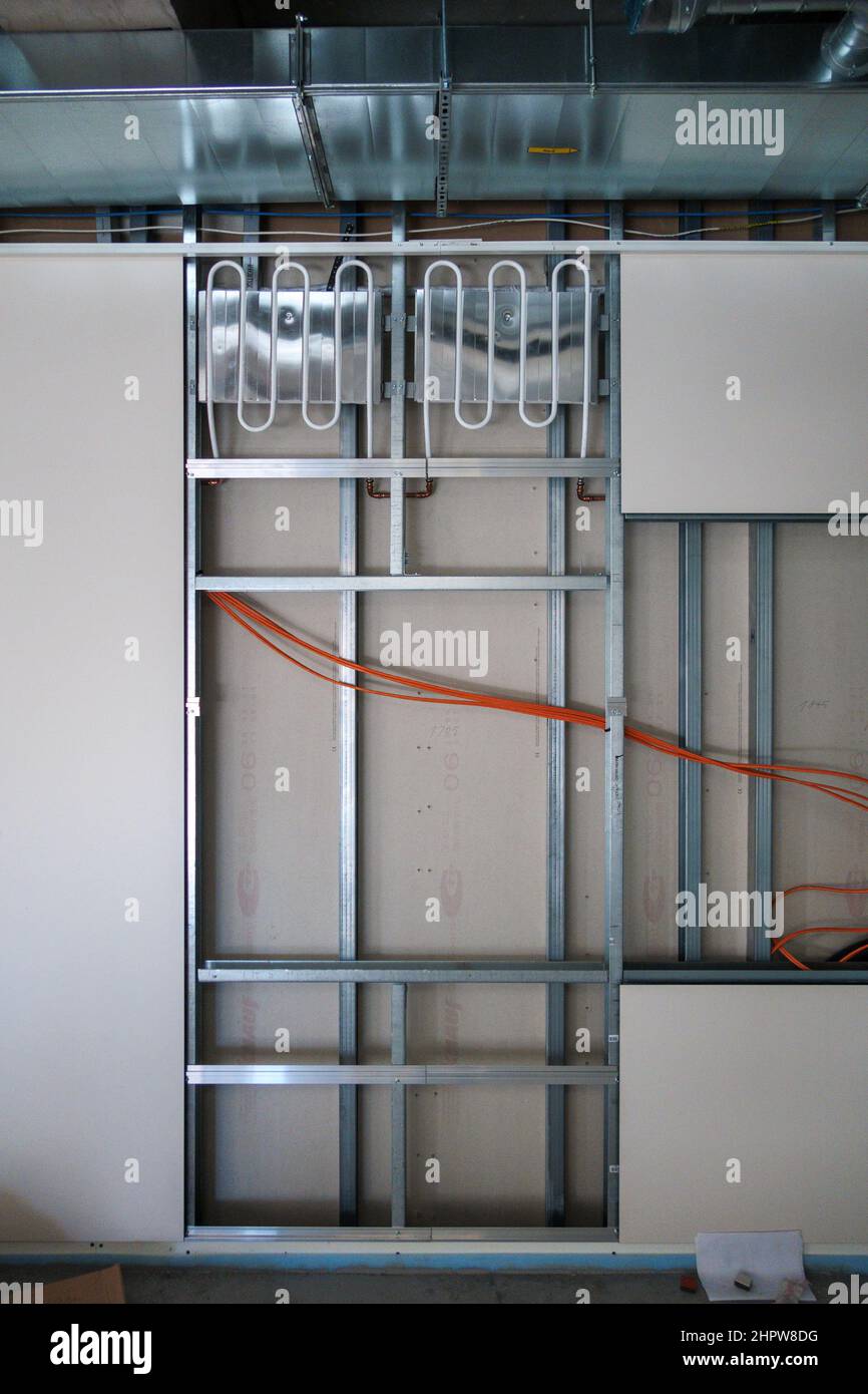 behind the panels of a drywall run cables and a wall heater Stock Photo ...