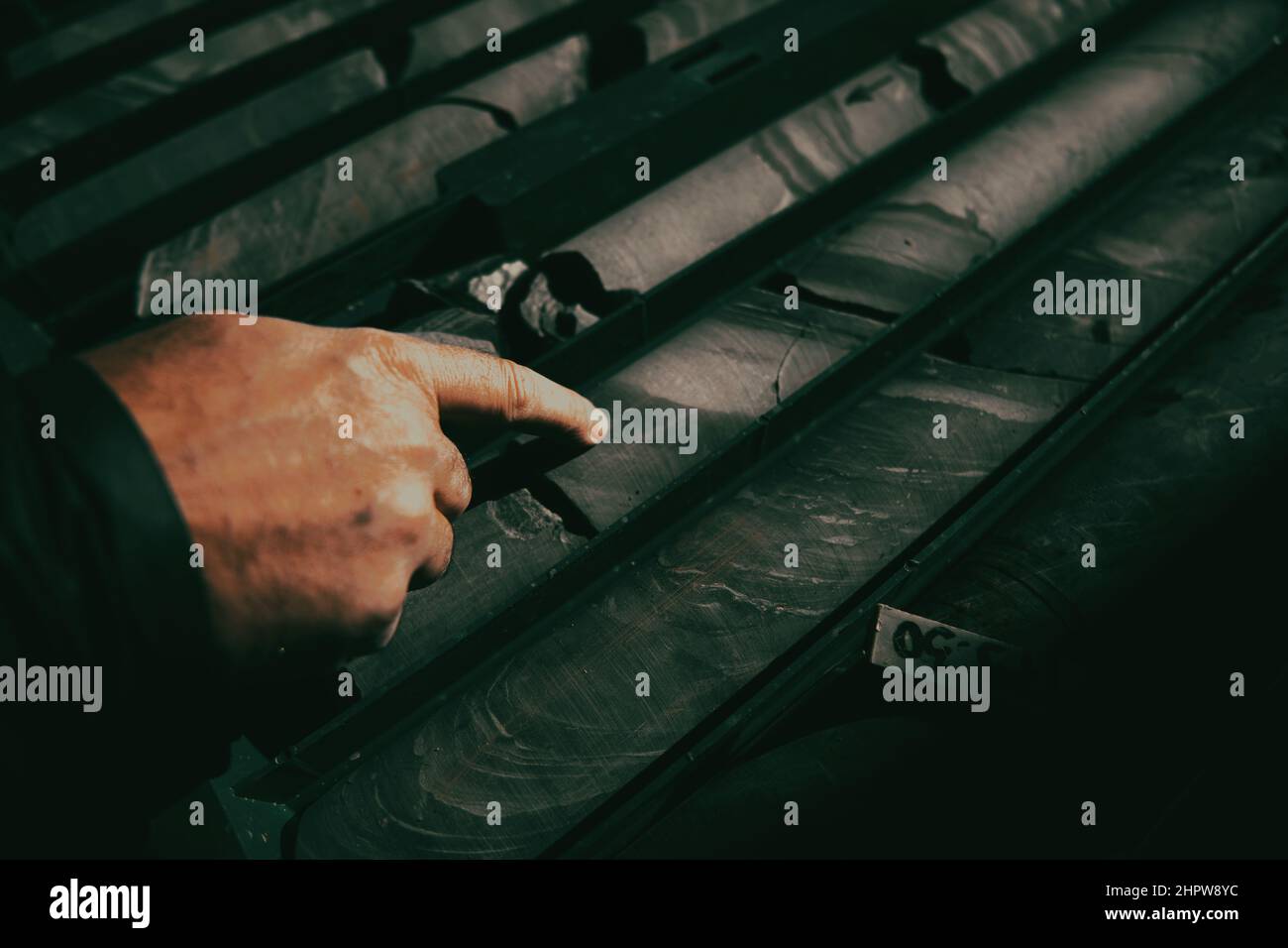 Geological gold core samples with team of mining workers measuring ...