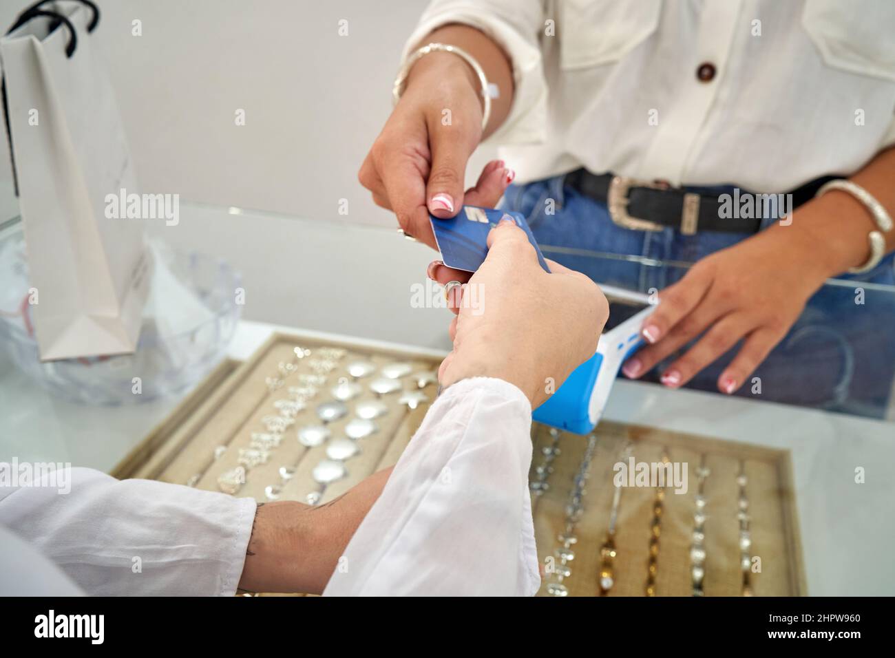 Customer touching credit card on terminal held by manager Stock Photo ...