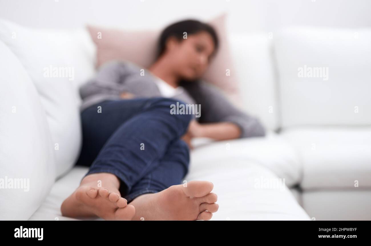 Taking a cat nap. A young woman taking a nap on her sofa Stock Photo ...