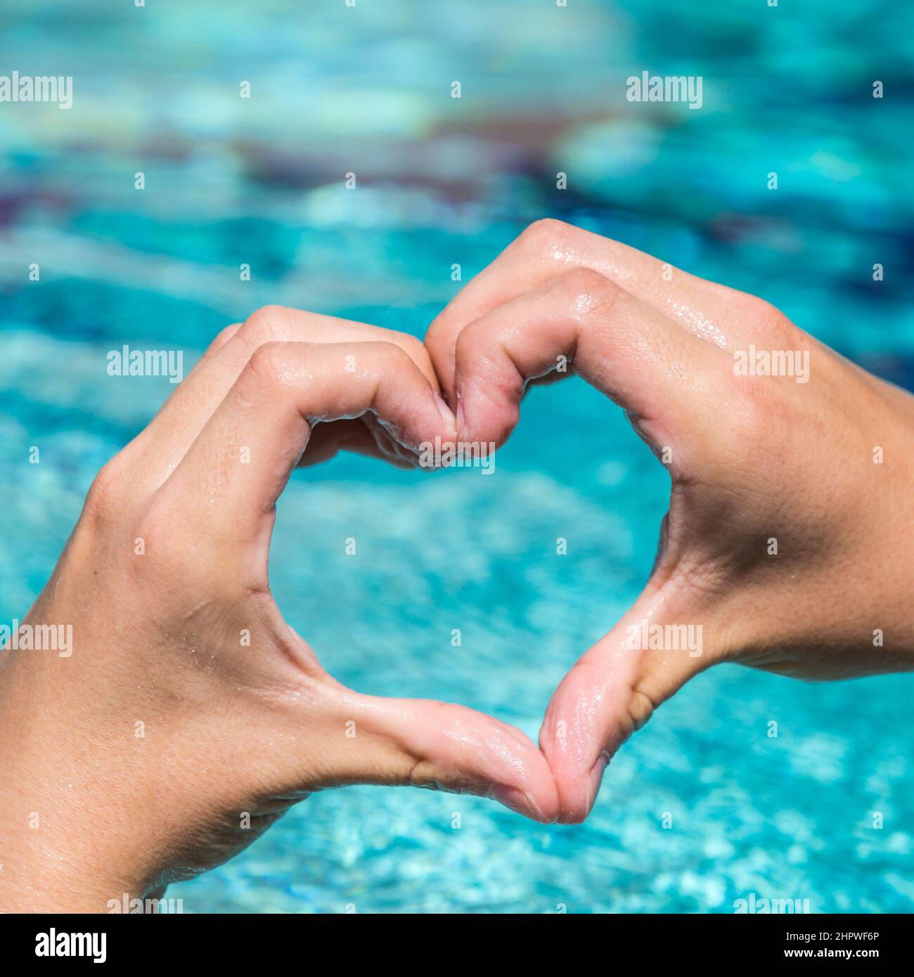 young man shows love sign with heart shape formed by hands Stock Photo ...