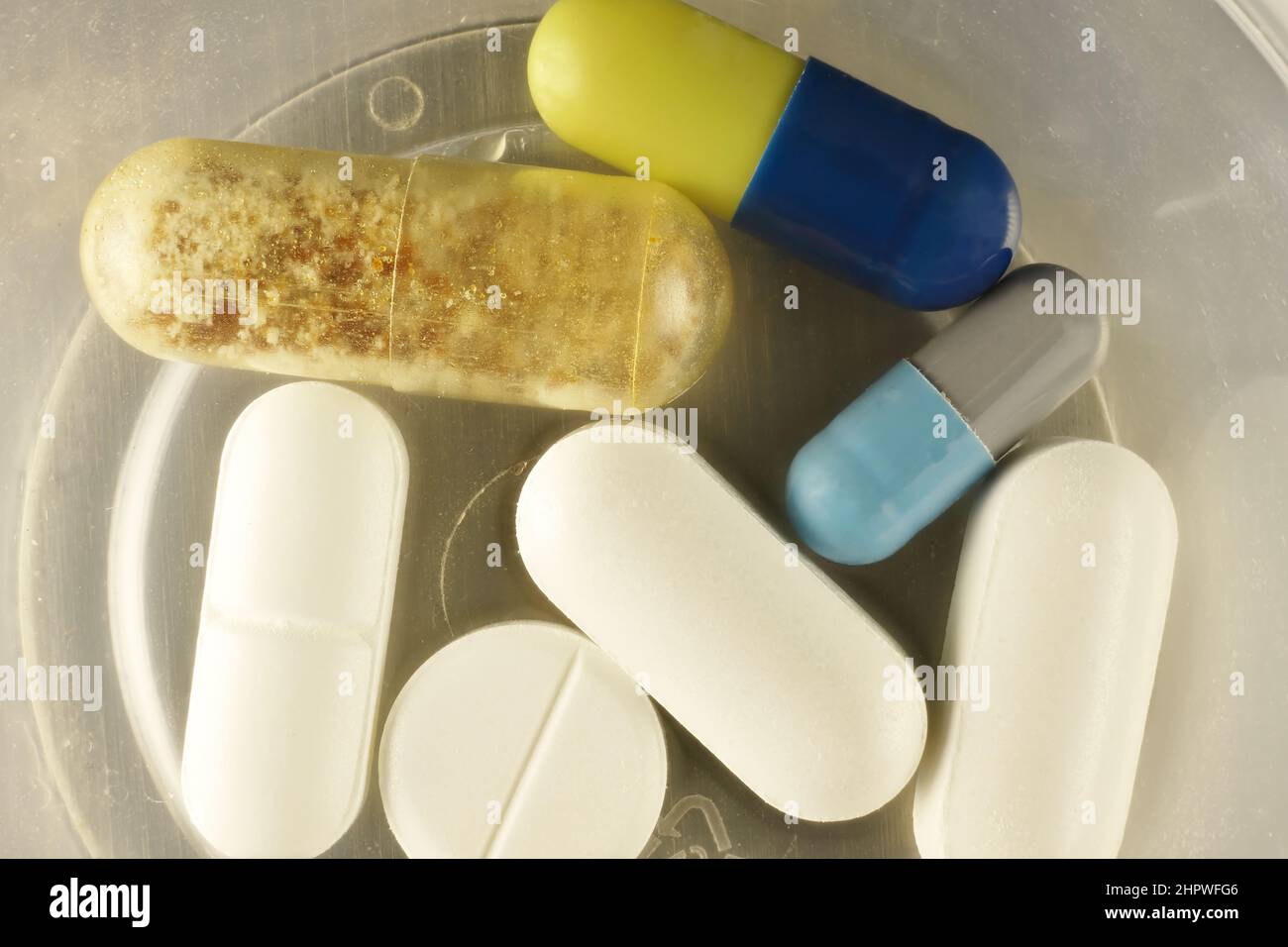 Macro view of medication cup with tablets and capsules Stock Photo - Alamy