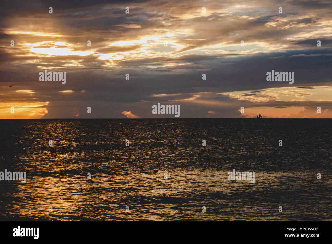 Dramatic sunset rays of light through clouds and horizon Stock Photo ...