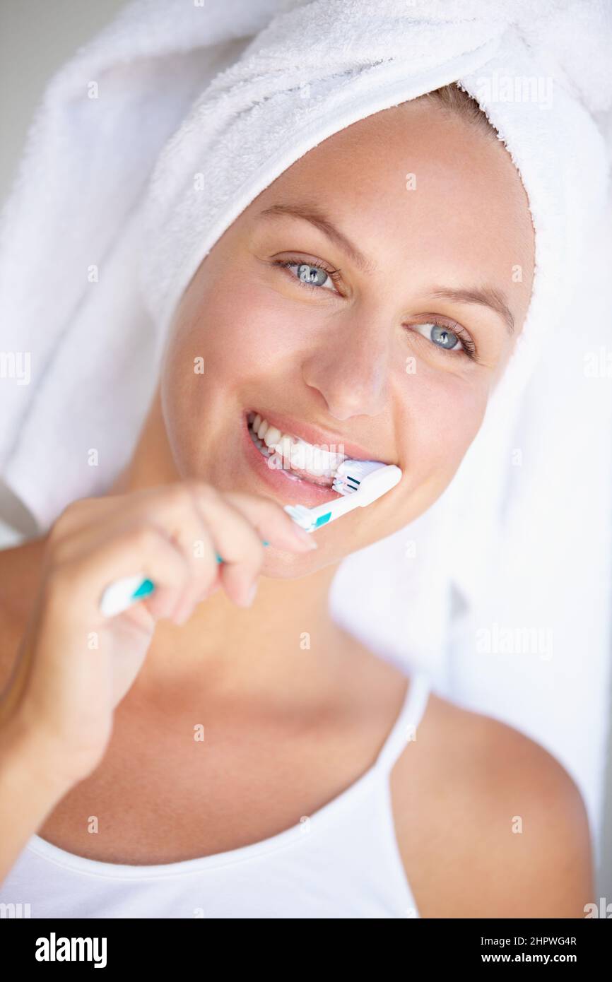 Maintaining the perfect smile. Shot of a beautiful woman brushing her ...