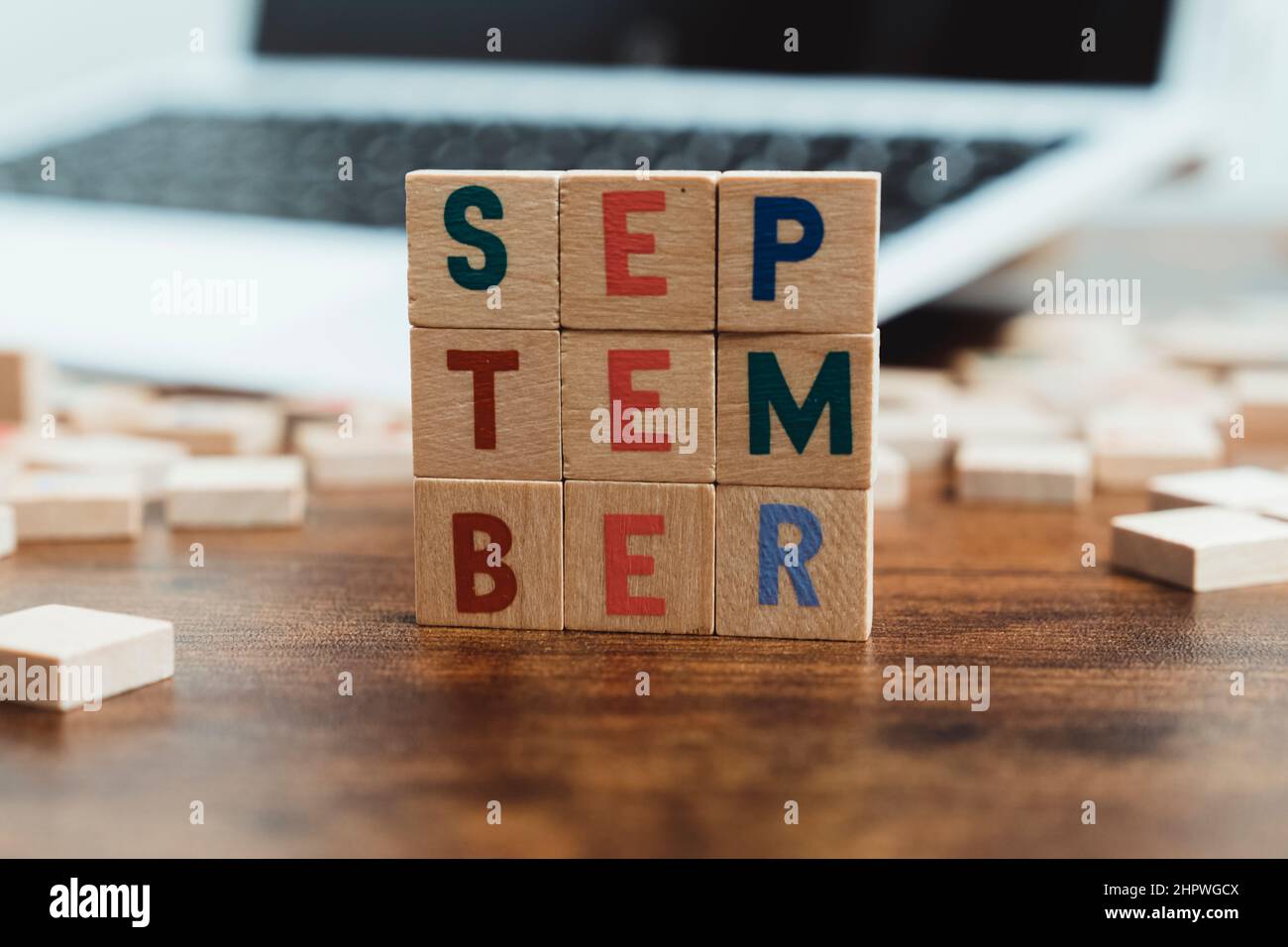 The name of the month September written on wooden cubes od the tabletop ...