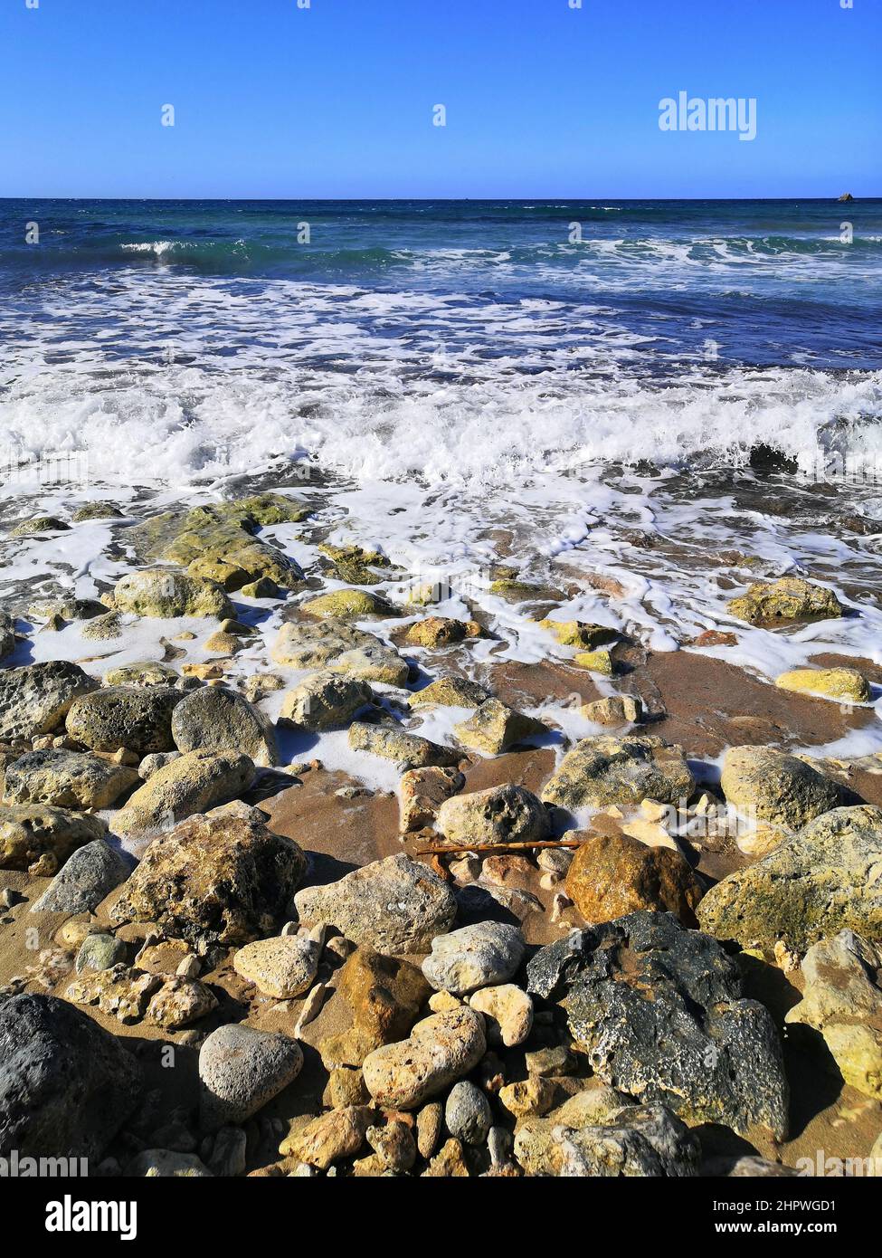 Beautiful view of the wavy sea hitting the rocky beach Stock Photo - Alamy