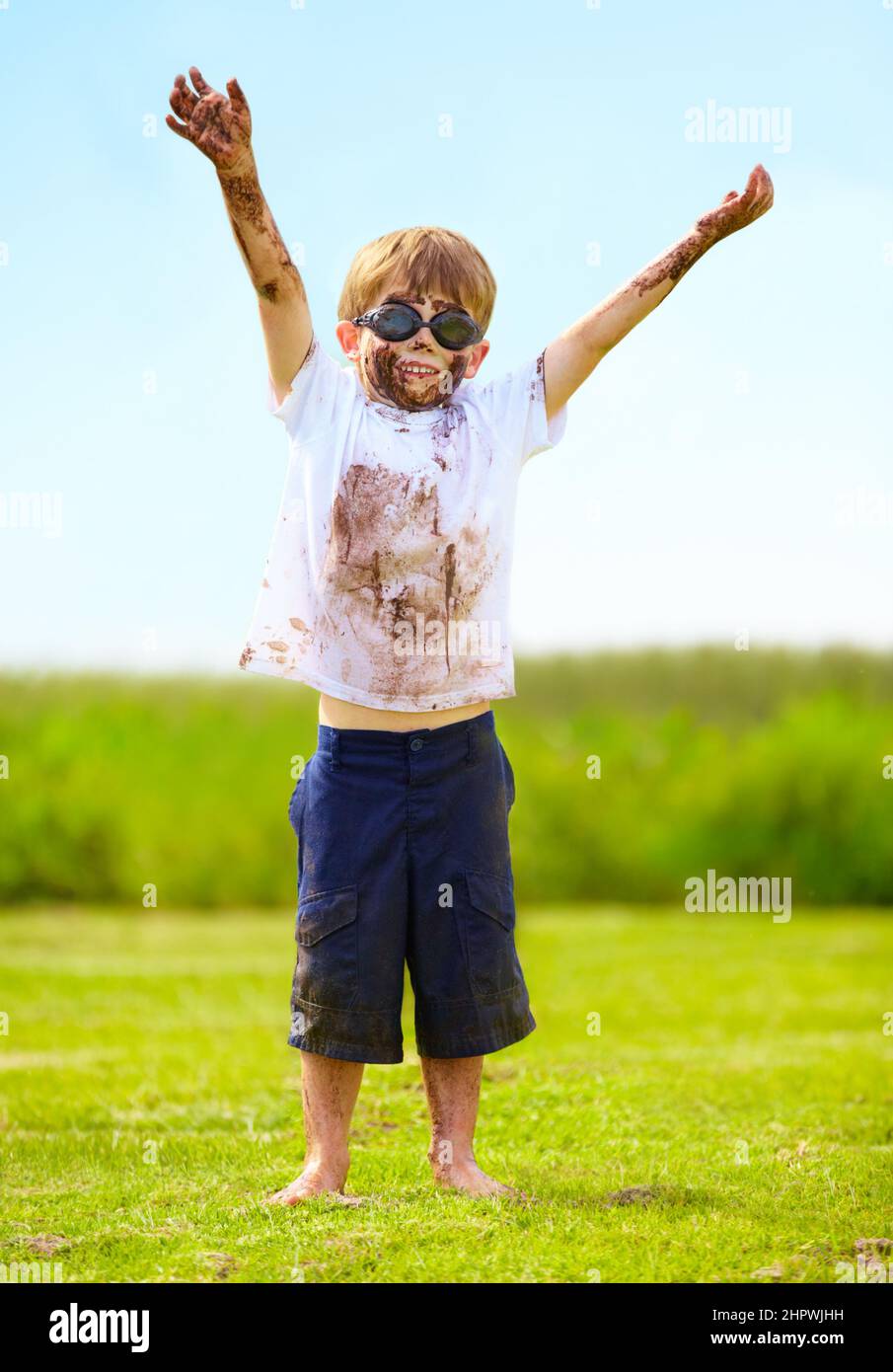 A muddy superhero. A little boy dressed as a superhero and covered in ...