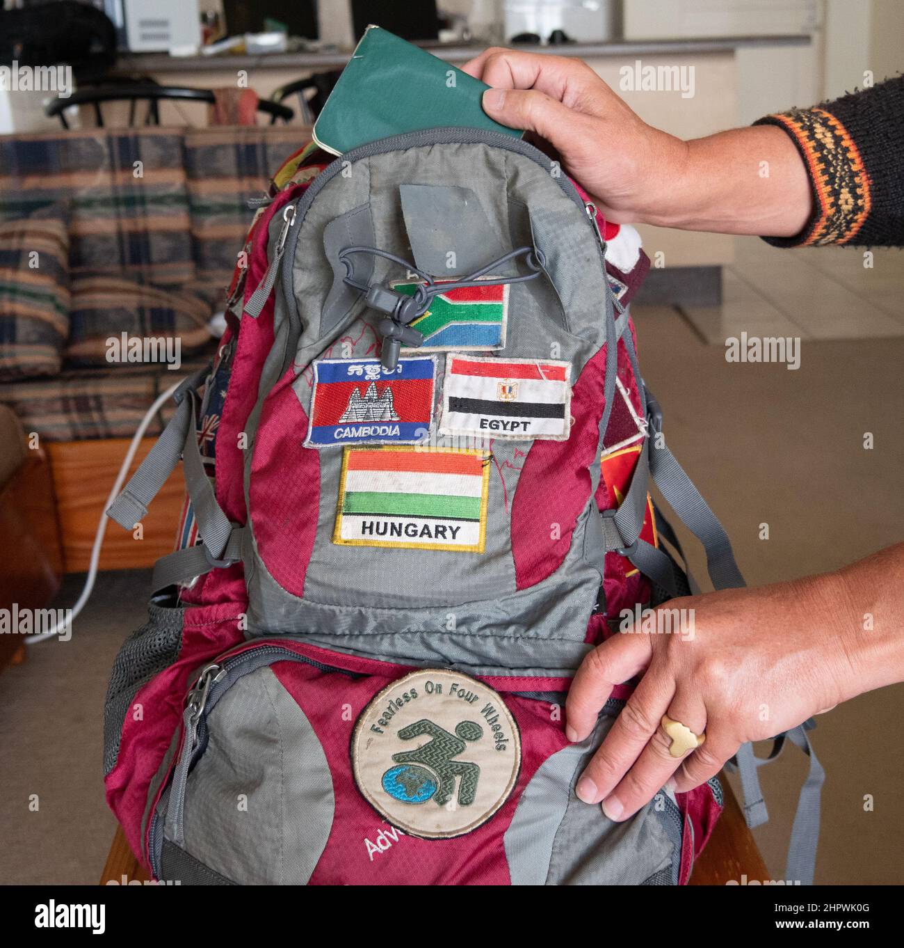 Getting ready to travel, packing passport into backpack which is ...