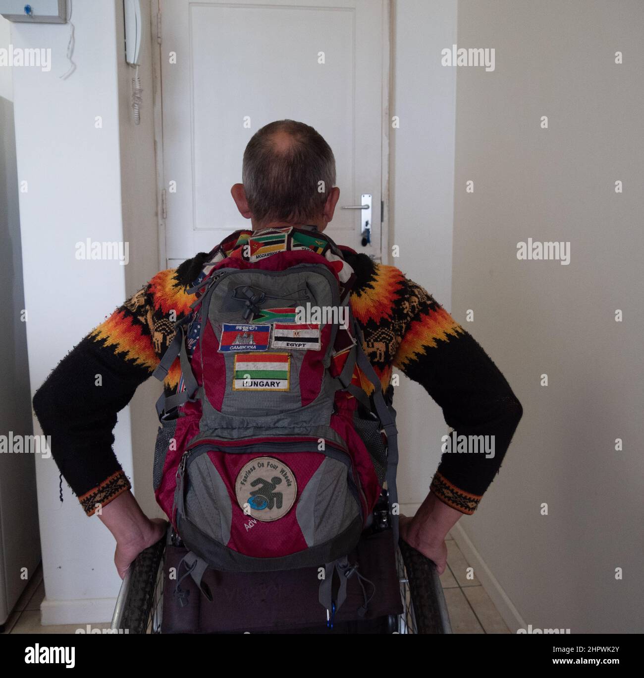 Man in wheelchair getting ready to travel. He is leaving the house ...