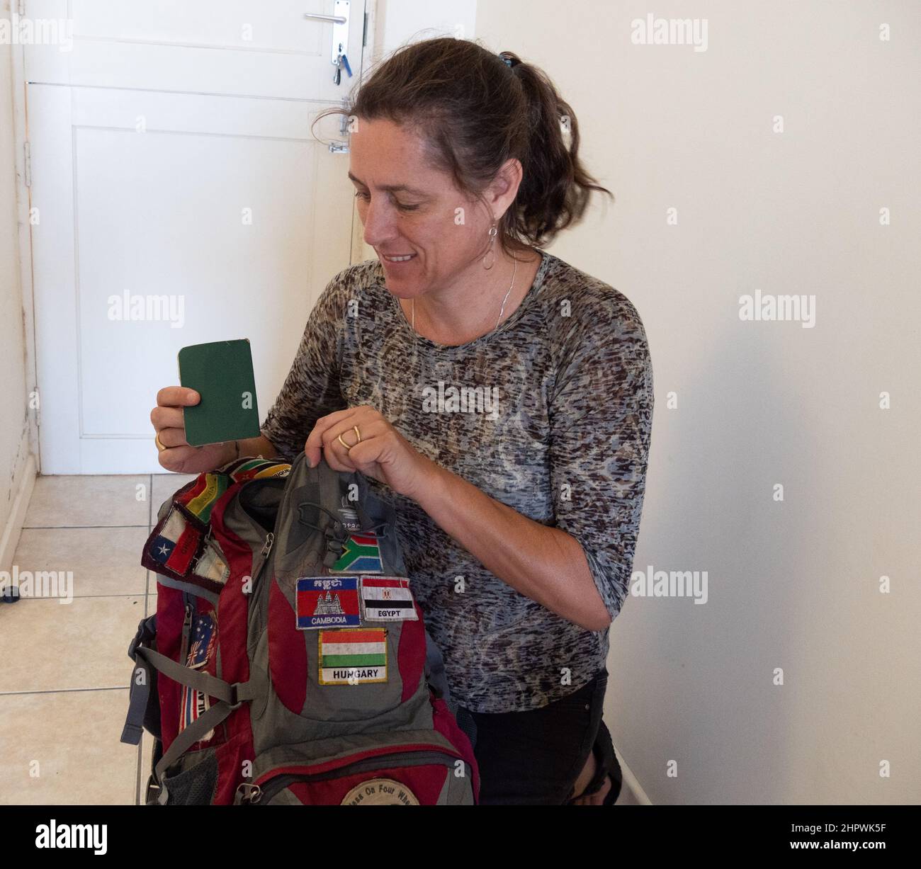 Woman getting ready to travel. She is packing her passport in her ...