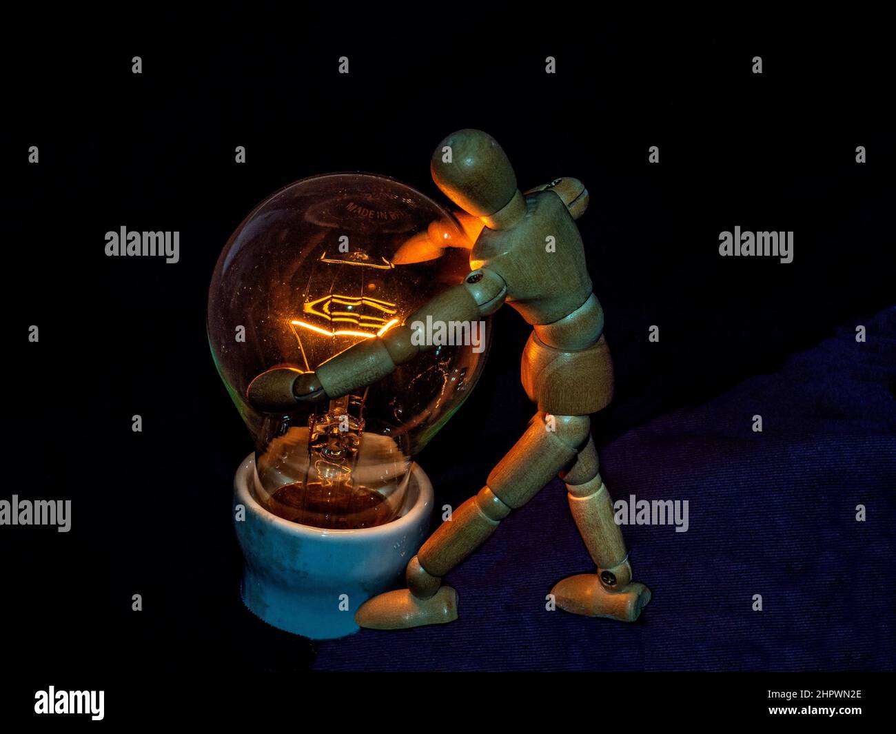 Still life, wooden figure with light bulb, symbol photo energy ...