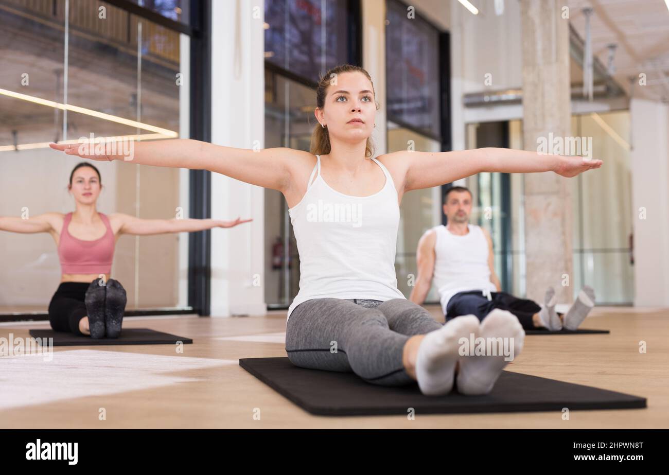 Young woman doing pilates workout with group at gym Stock Photo - Alamy