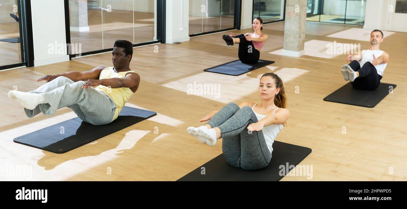 Young adults exercising during pilates class in fitness center Stock ...