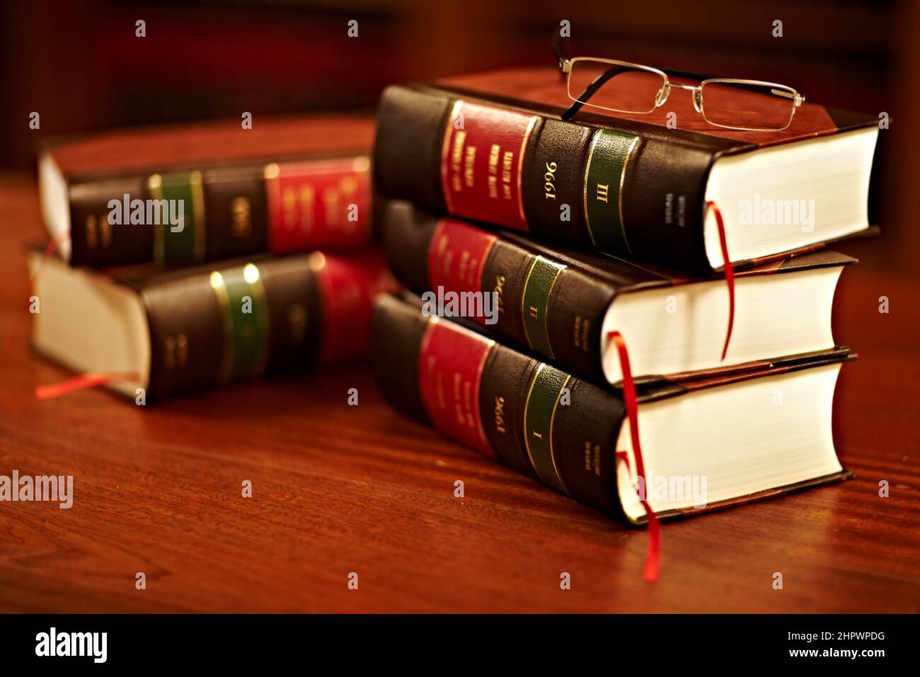 Get to know your rights. Shot of a stack of legal books and a pair of ...