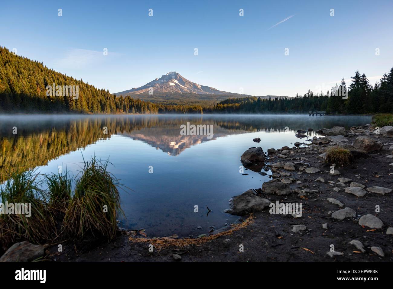 Lake shore, reflection of Mt. Hood volcano in Trillium Lake, in morning ...