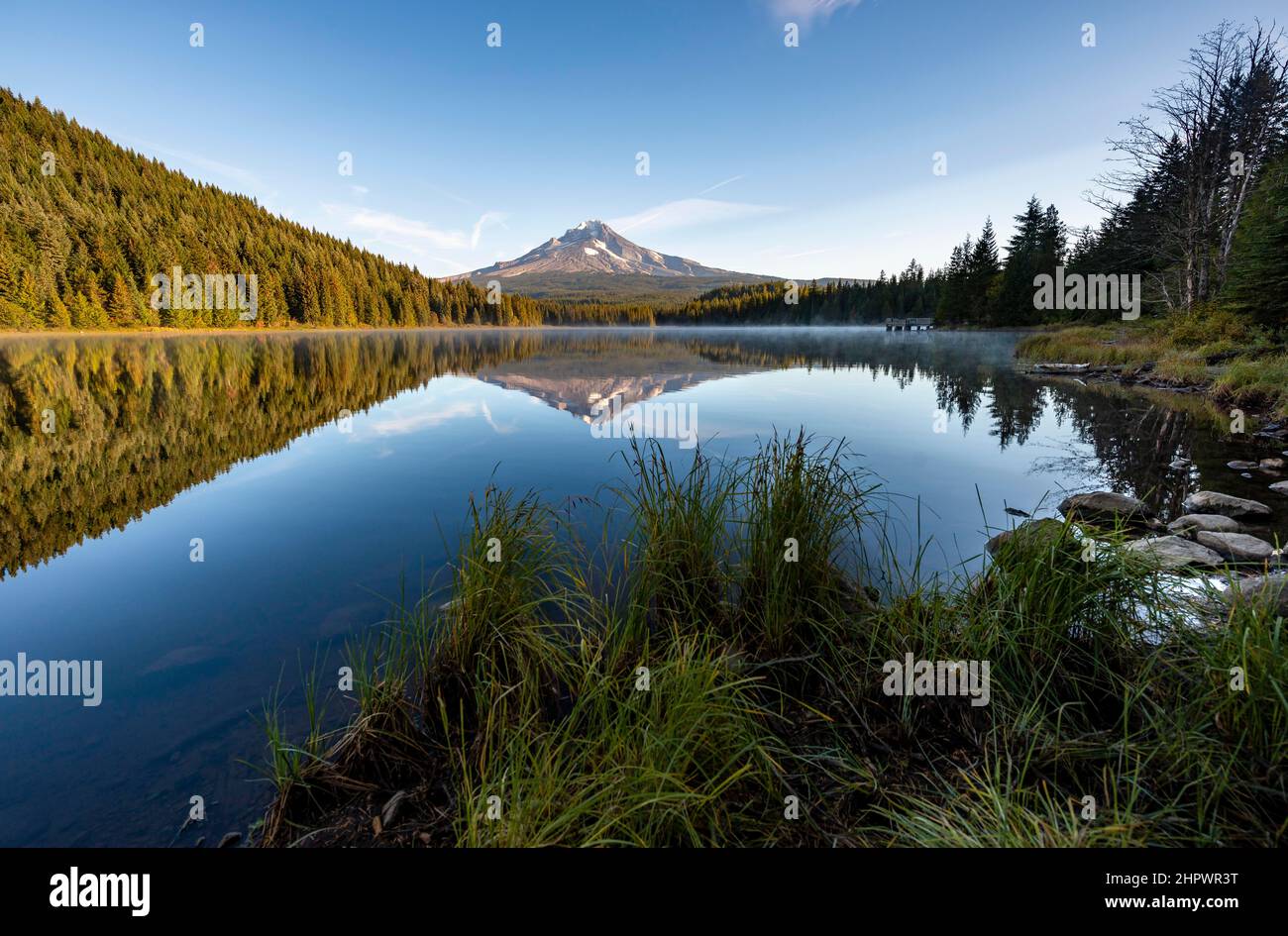 Lake shore, reflection of Mt. Hood volcano in Trillium Lake, in morning ...