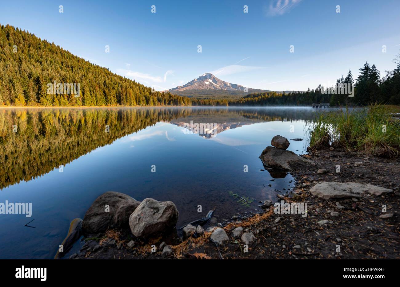 Lake shore, reflection of Mt. Hood volcano in Trillium Lake, in morning ...