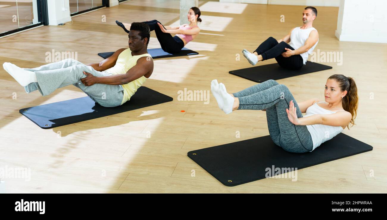 Sporty people doing stretching workout during pilates training Stock ...