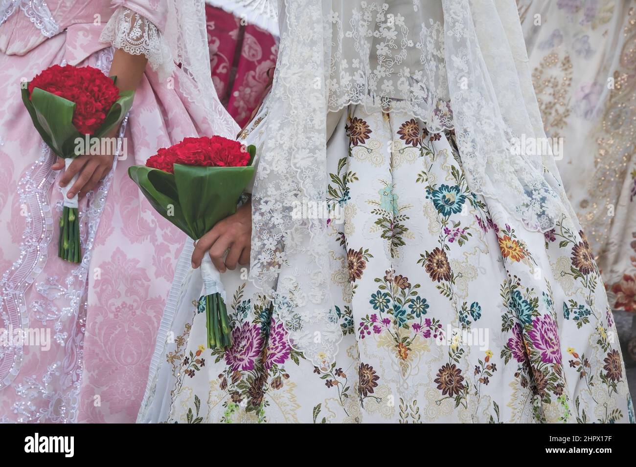 Detail of traditional Spanish floral dresses with flower offering at ...