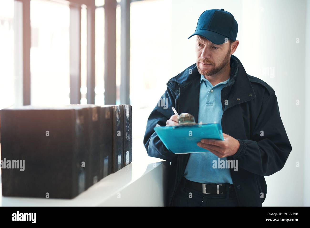 Making sure every delivery is signed and dated. Shot of a handsome ...