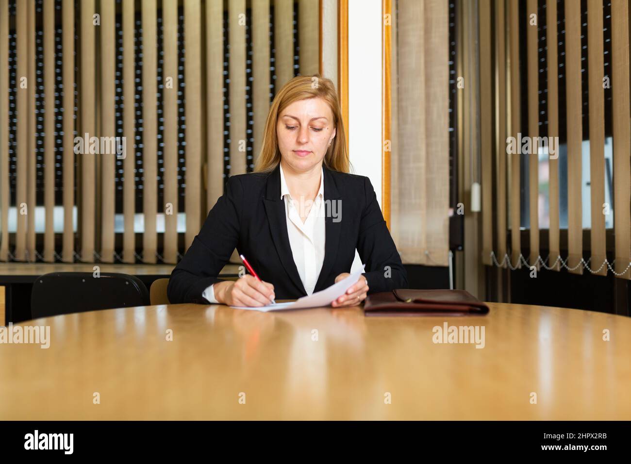 Business woman in office interior filling up documents Stock Photo - Alamy