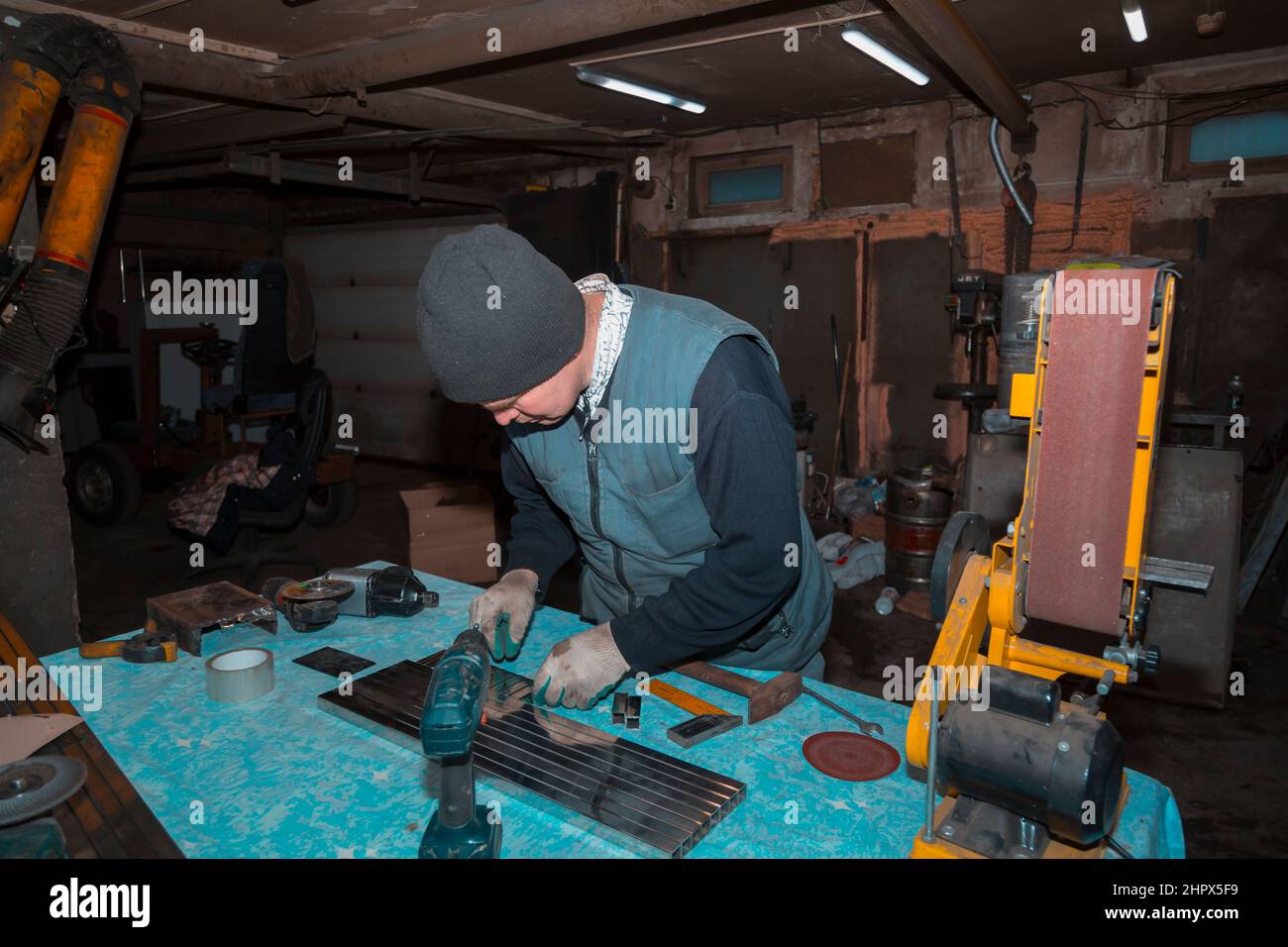 A worker marks a stainless steel profile pipe with a marker using a ...