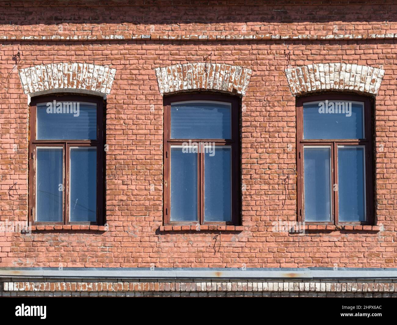 Three windows of the old mansion 19 century with brown bricks wall ...