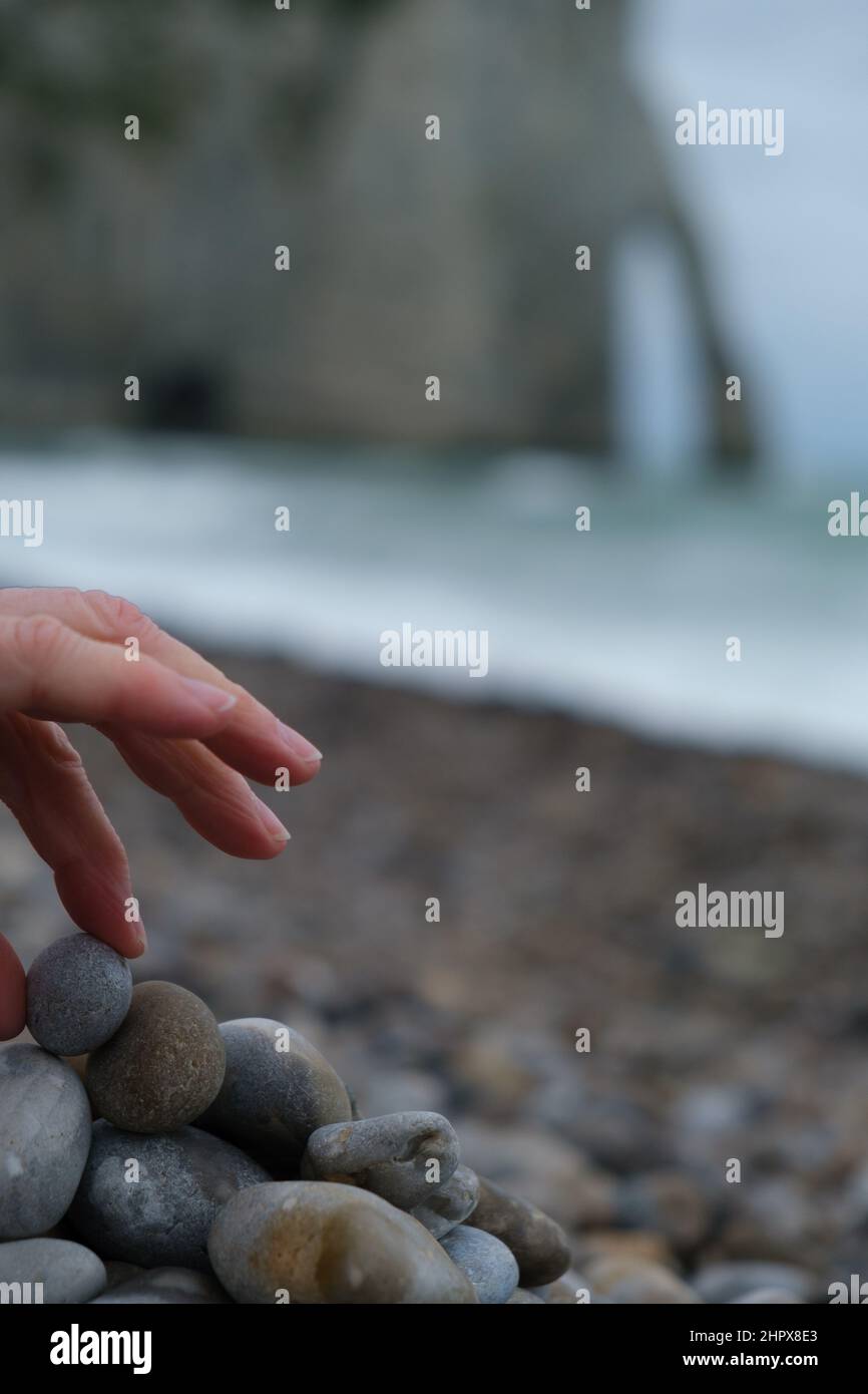 Woman's hand stacking rocks with soft focus background Stock Photo - Alamy